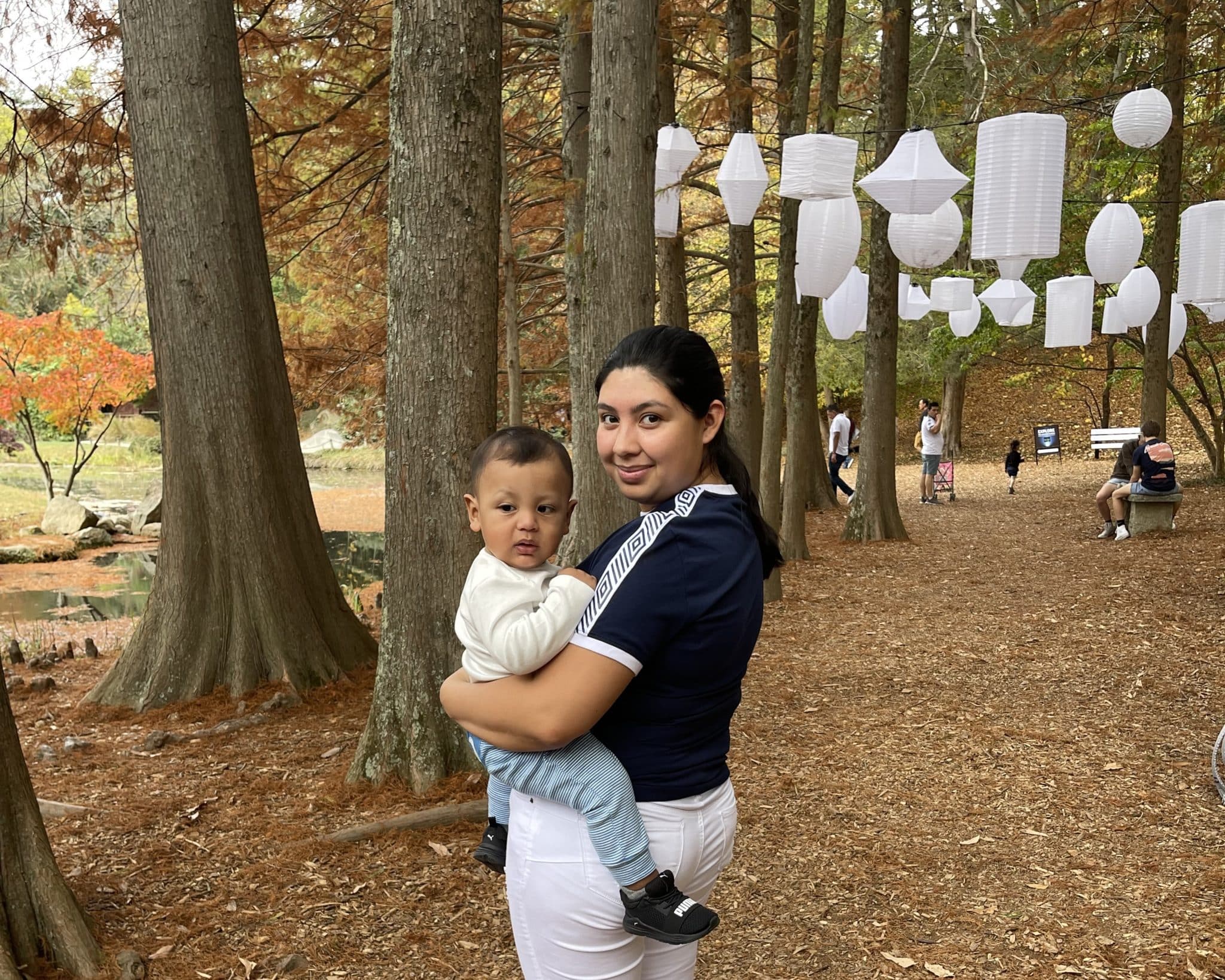 Katherine and baby in the woodlands of the Japanese Garden with lanterns during Garden Glow ...